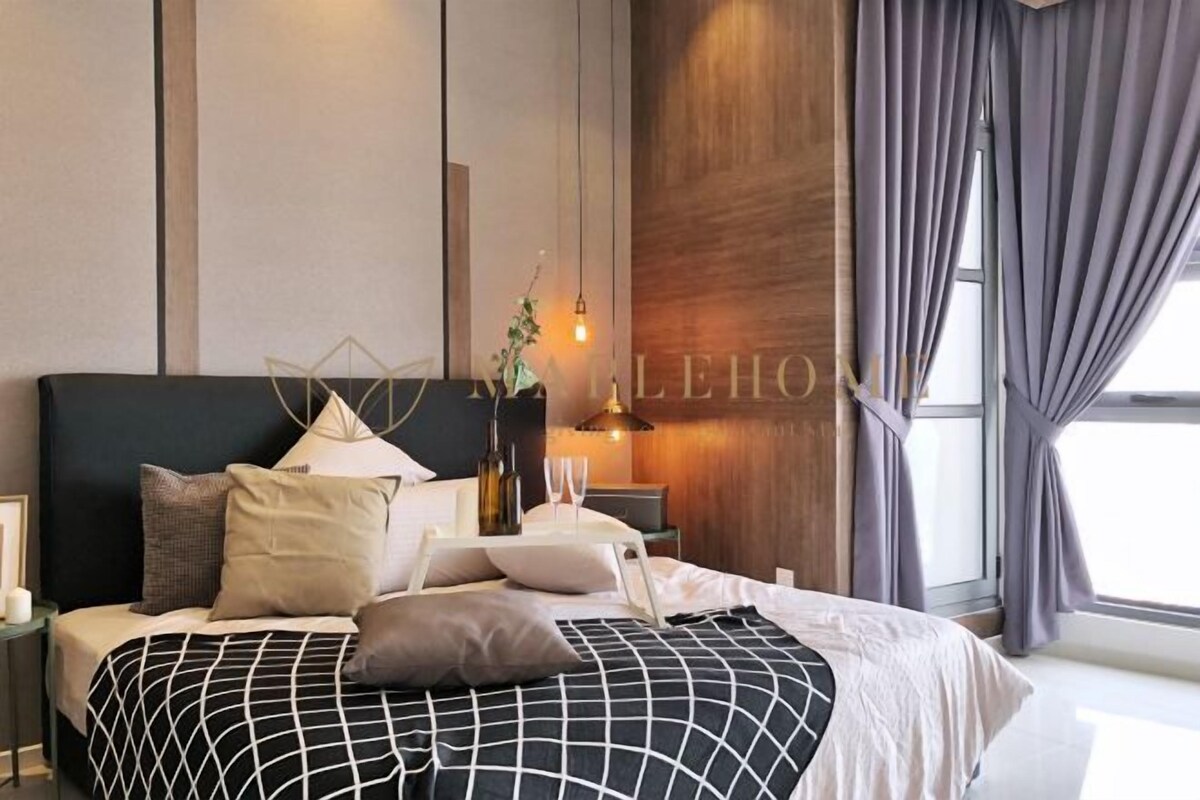 Quarto moderno com uma cama grande, mesa de cabeceira, abajur e janela com cortinas.