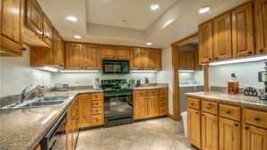 Uma placa de cozinha, uma máquina de lavar louça, utensílios de cozinha 