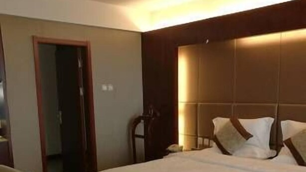 Quarto de hotel com uma cama grande, uma escrivaninha e uma cadeira.