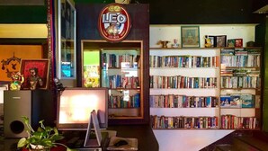 Uma livraria com uma placa de destaque 'LEO BEER', diversas estantes e um laptop sobre uma mesa.
