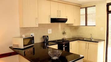 Um frigorífico, um micro-ondas, um forno, uma placa de cozinha