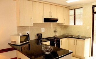 Um frigorífico, um micro-ondas, um forno, uma placa de cozinha 