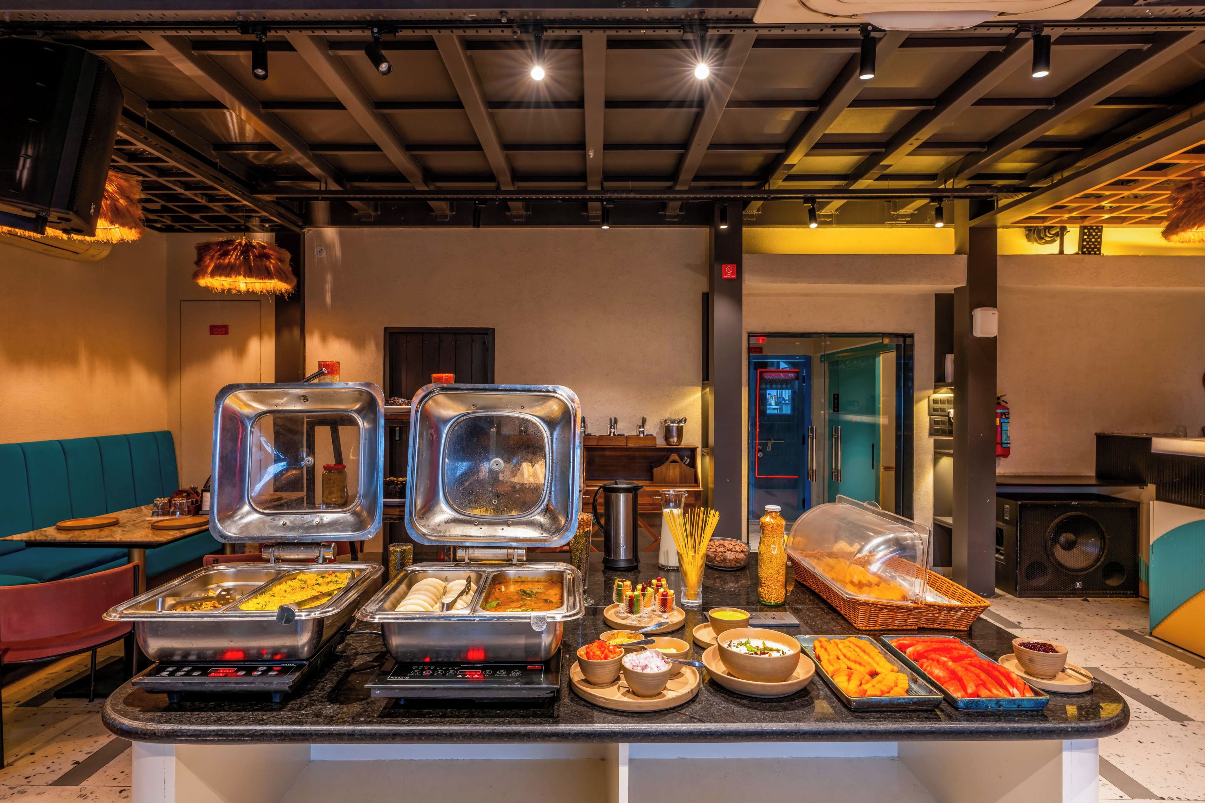 Uma área de buffet com diversas opções de comida e diferentes arranjos de assentos.