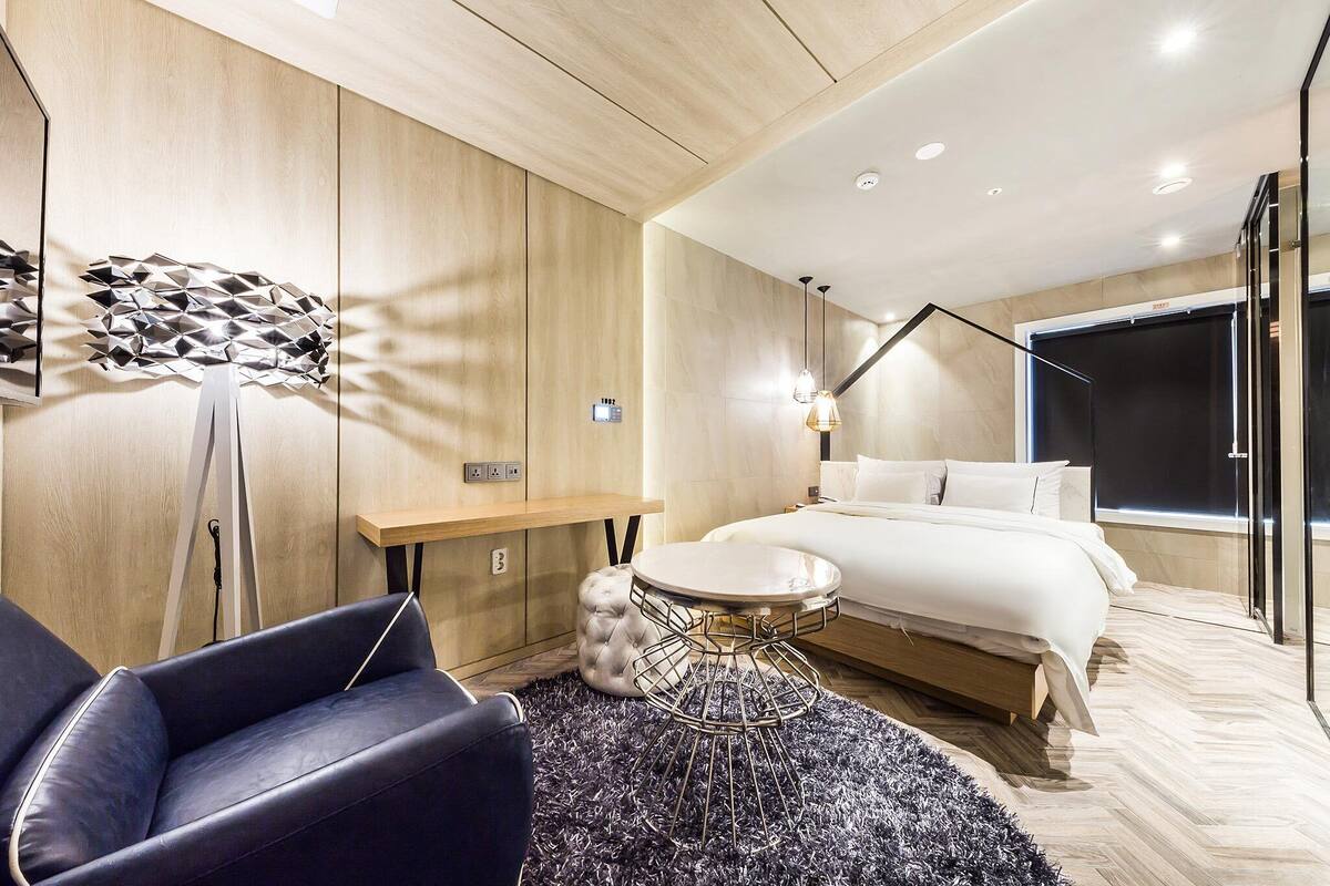 Quarto de hotel moderno com cama, escrivaninha e cadeira.