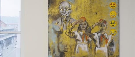 Pintura com figuras abstratas e emojis numa parede.