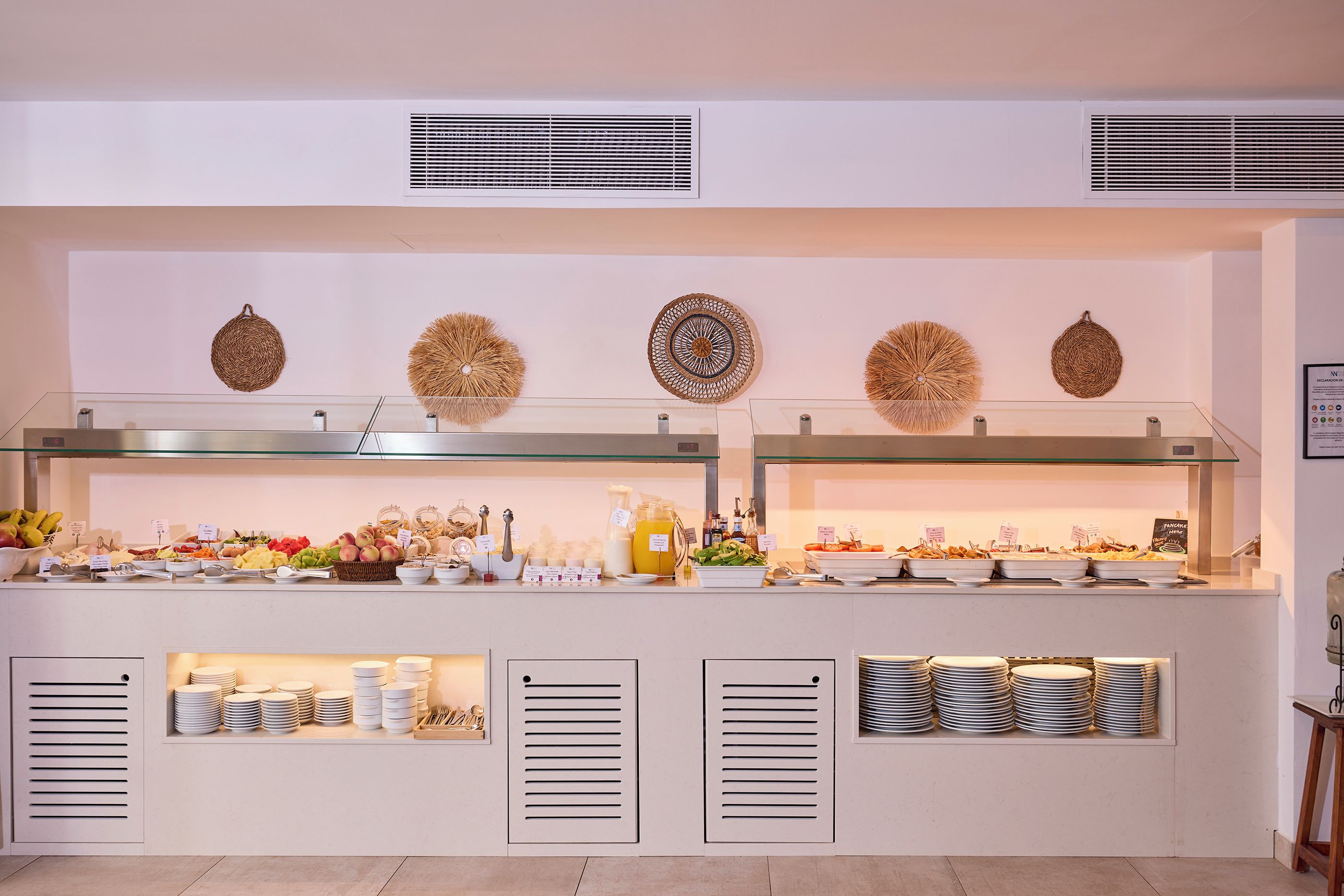 Disposição de buffet com diversos tipos de comida e decorações nas paredes.