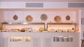 Disposição de buffet com diversos tipos de comida e decorações nas paredes.