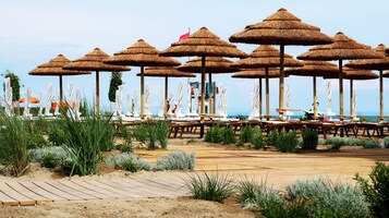 Na praia, espreguiçadeiras, guarda-sóis, toalhas de praia