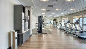 Uma academia moderna com esteiras, bicicletas ergométricas e aparelhos de musculação.