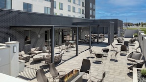 Um terraço no telhado com área de estar externa e lareira.