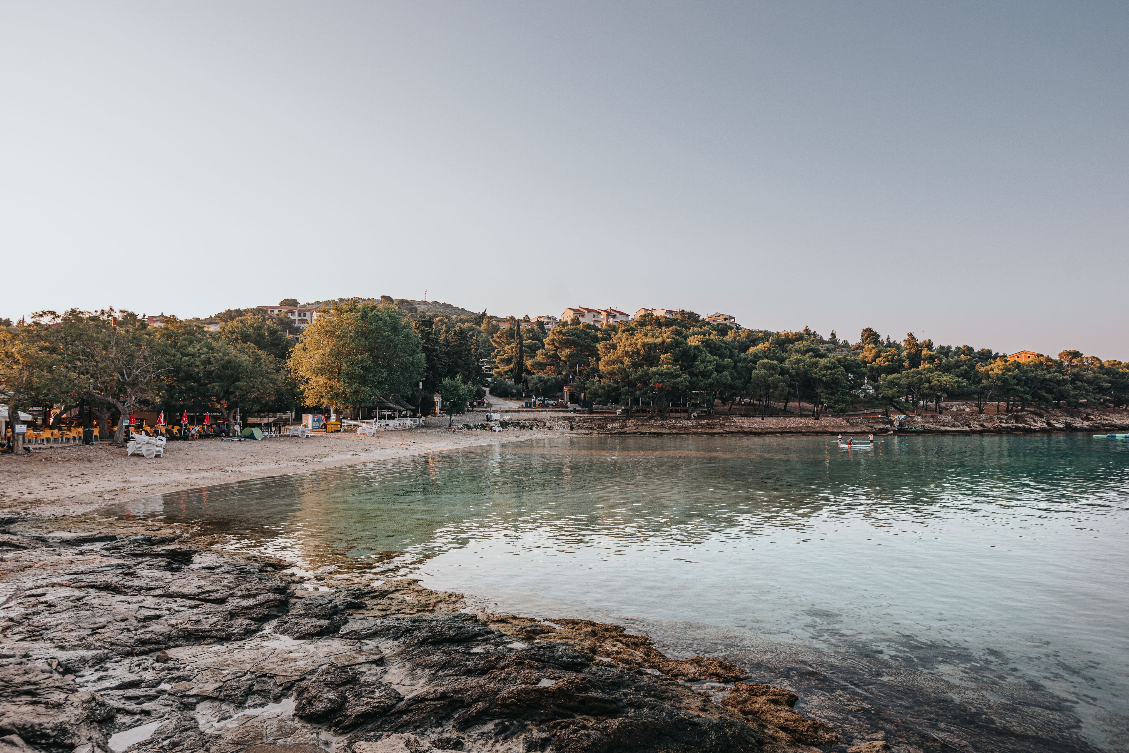 Na praia, praia de areia branca, espreguiçadeiras, guarda-sóis de praia 