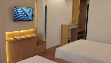 Quarto de hotel com duas camas, televisão presa na parede e guarda-roupa de madeira com espelho.