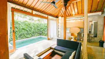 Sala de estar moderna com piscina, teto de madeira e janelas amplas.