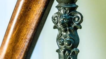 Detalhe de uma perna de cadeira de madeira com um ornamental de metal.