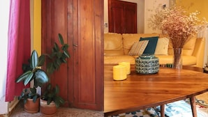 Sala de estar com sofá, mesa de centro de madeira e plantas em vasos.