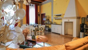 Uma sala de estar aconchegante com sofá, mesa de jantar com cadeiras, cozinha com fogão e lareira.
