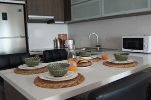 Apartamento | Cozinha privada | Uma cafeteira/bule, uma cadeira de bebé, utensílios de cozinha 