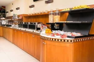 Buffet montado com diversos alimentos e recipientes.