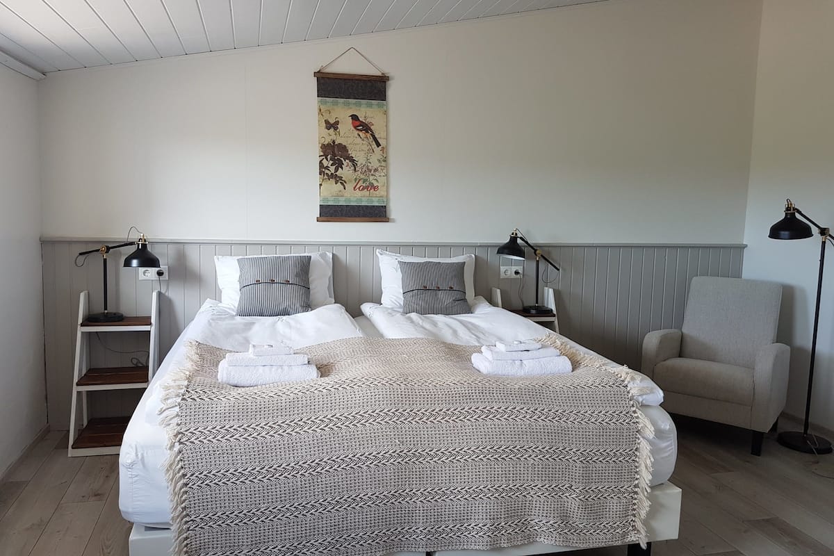Quarto casal superior, banheiro privativo (Fjósið) | Cortinas blackout, ferros/tábuas de passar roupa, berço de viagem