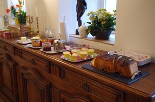 Um buffet de café da manhã com diversos alimentos e bebidas sobre um balcão de madeira.