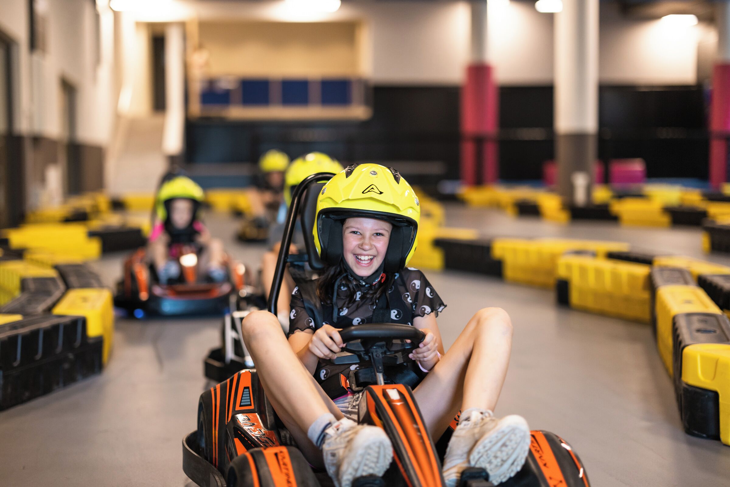 Uma pista de go-kart com vários kart e pilotos.
