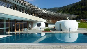 Um edifício moderno com piscina, portas de vidro e design arquitetônico único.