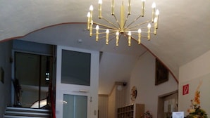Uma cozinha moderna com bancada de madeira, forno embutido e luminária pendente.