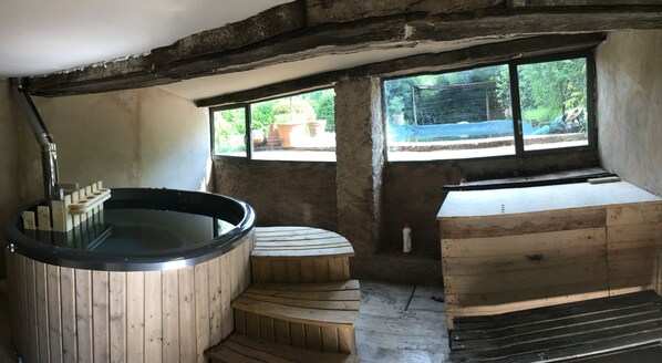 Uma sauna de madeira rústica com um banco de madeira e uma banheira de hidromassagem.