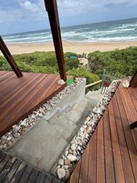 Na praia, areia branca, espreguiçadeiras, guarda-sóis 