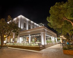 Um hotel moderno com área de estar ao ar livre espaçosa, janelas amplas e entrada bem iluminada.