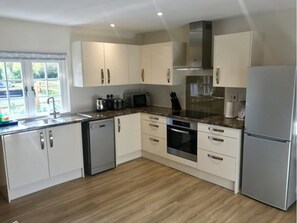 Apartamento, 2 quartos | Cozinha privada | Um frigorífico, um micro-ondas, um forno, uma placa de cozinha 