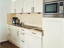 Um frigorífico, um micro-ondas, uma placa de cozinha 