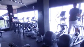 Uma academia com diversos equipamentos de ginástica, incluindo esteiras e bicicletas ergométricas.