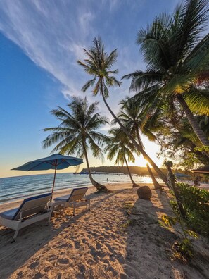 Praia particular, espreguiçadeiras, guarda-sóis, toalhas de praia 