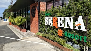 Exterior do Serena Resort, com fachada de tijolos, janelas amplas e uma placa com o nome do resort.