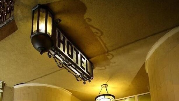 Entrada de hotel com uma escadaria que leva a uma porta giratória.