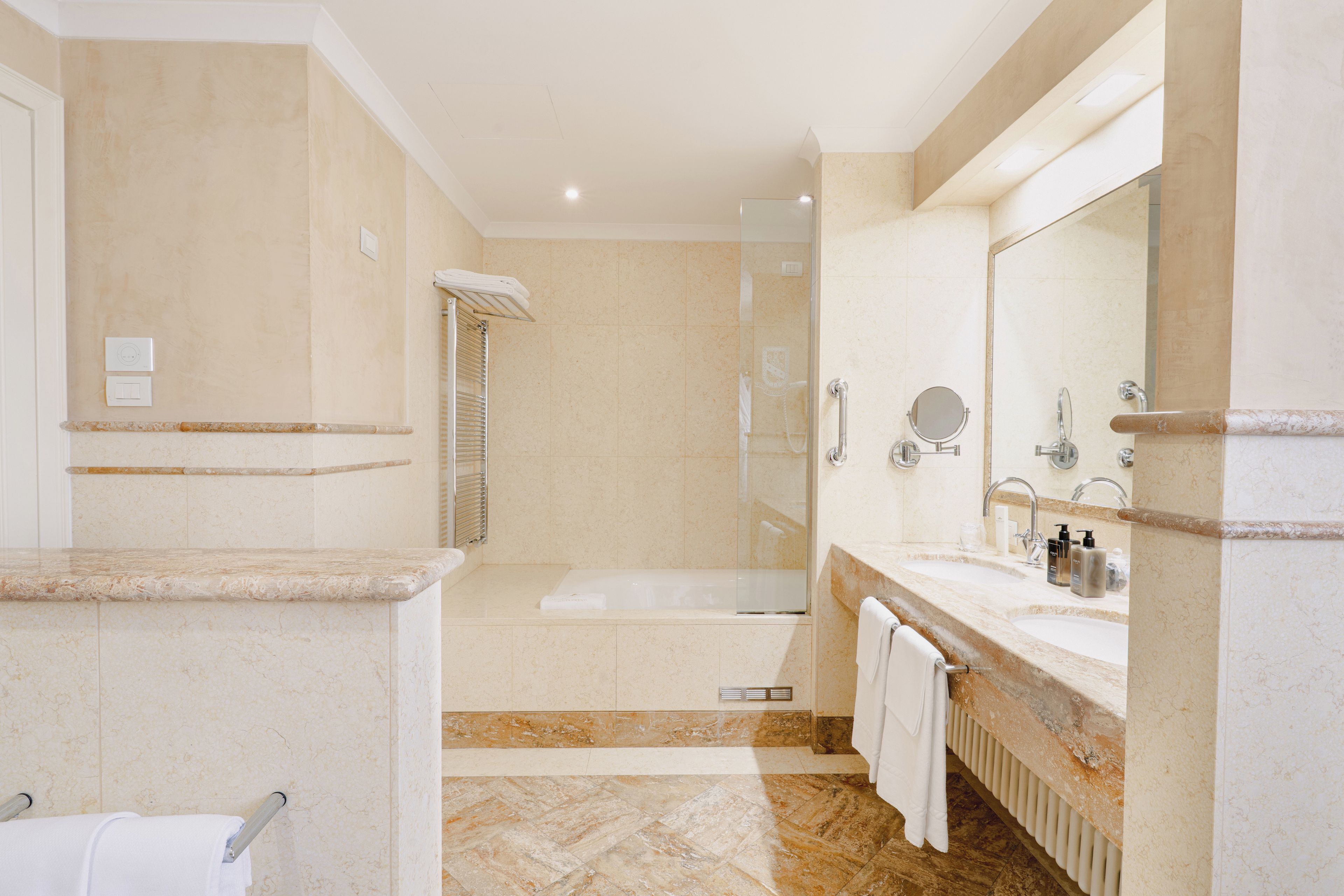 Um banheiro moderno com banheira, chuveiro e toucador com um espelho grande.