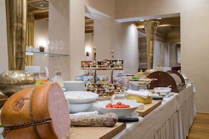 Disposição de buffet com diversos alimentos e acompanhamentos.