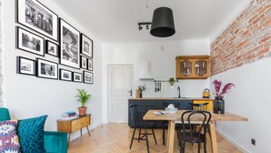 Uma cozinha compacta com área de refeições, parede de tijolos e vários quadros pendurados na parede.