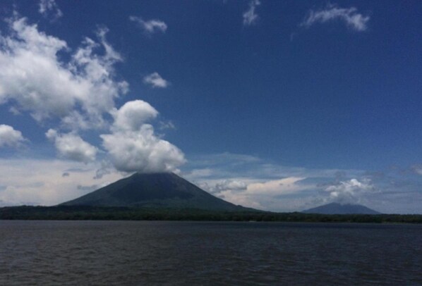 Uma montanha com uma nuvem no topo, vista de um corpo d'água.