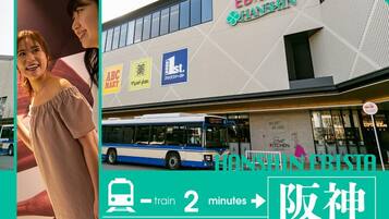 Um edifício com uma placa indicando Ebista Hanshin e um ponto de ônibus.