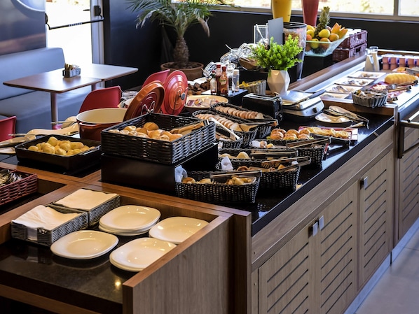 Disposição de buffet com diversos alimentos e utensílios.