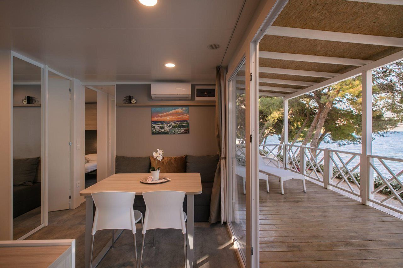 Um quarto aconchegante com uma mesa e cadeiras de madeira, um sofá e um quadro na parede.