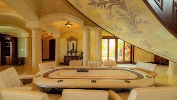 Quarto luxuoso com mesa de bilhar, assentos confortáveis e arquitetura clássica.