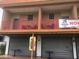 Um edifício com varanda, persianas fechadas e um letreiro com a palavra 'Medalla'.