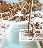 Na praia, barracas de praia de cortesia, espreguiçadeiras, guarda-sóis 