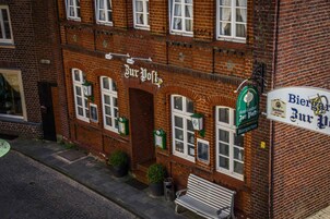 Um edifício de tijolos com uma placa que diz 'Biergarten Zur Post'.