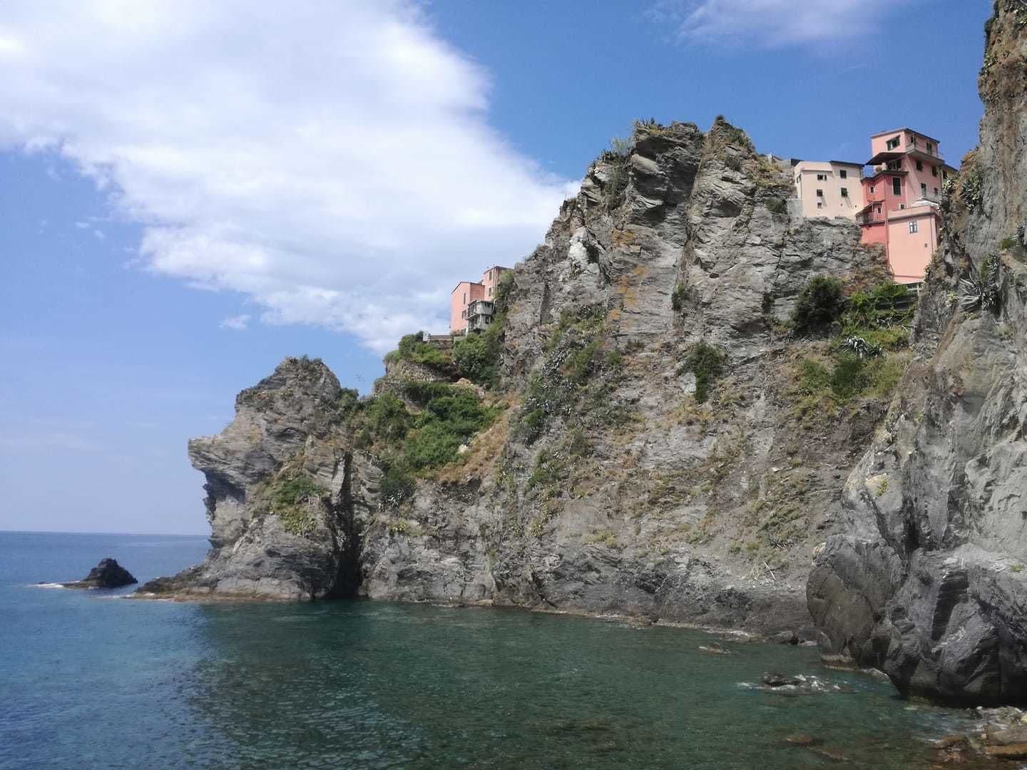 Um penhasco costeiro com edifícios no topo.