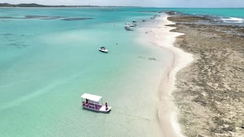 Na praia, espreguiçadeiras, guarda-sóis de praia, bares na praia