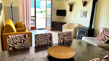 Apartamento superior, várias camas, vista parcial para o lago | Área de estar | TV de tela plana